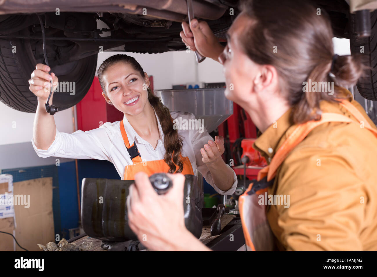 Handsome mechanic and beautiful female assistant working at the auto ...