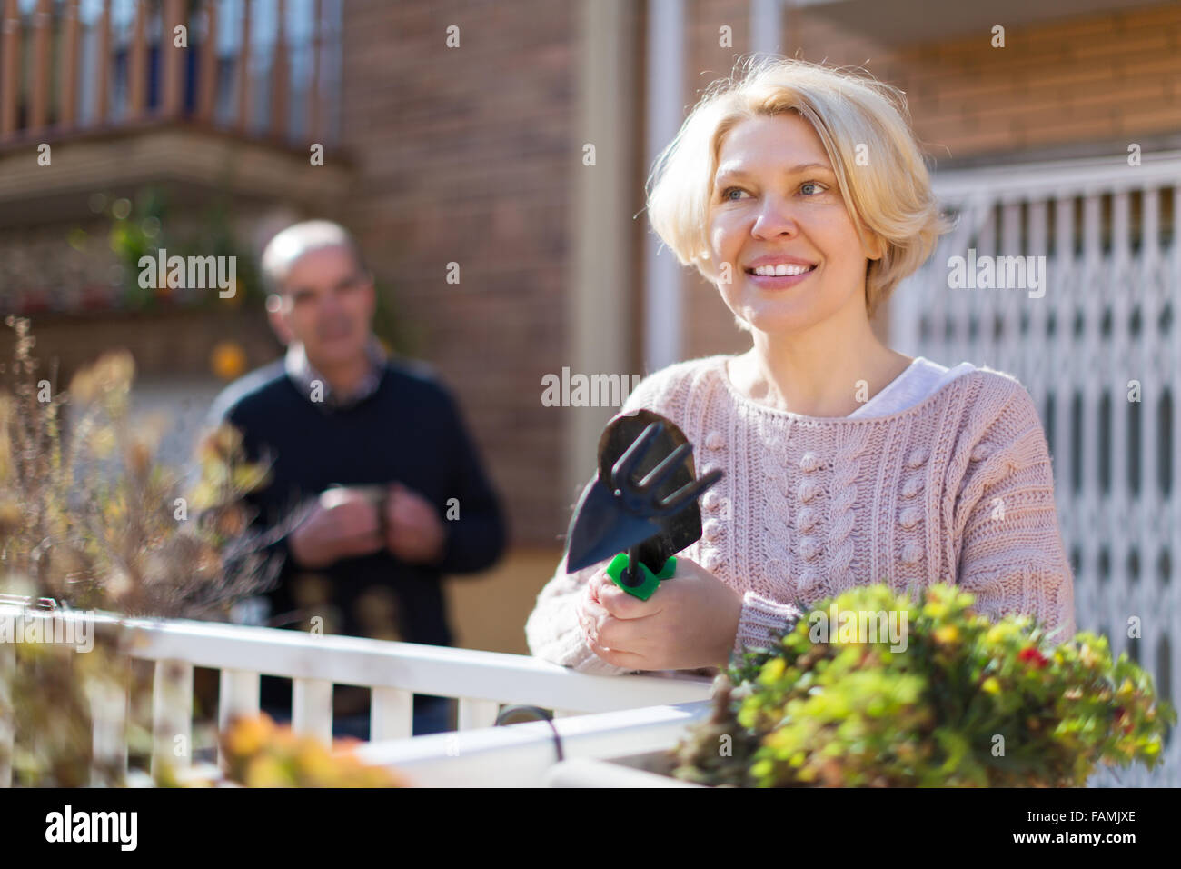 Mature positive woman talking with male neighbor at balcon Stock Photo ...
