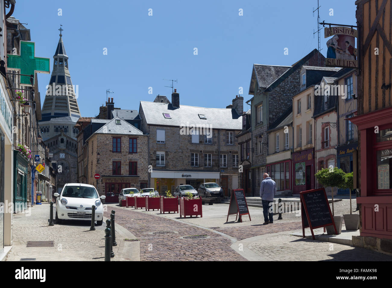 A man reads a sign in a medieval street and market square lined with ...