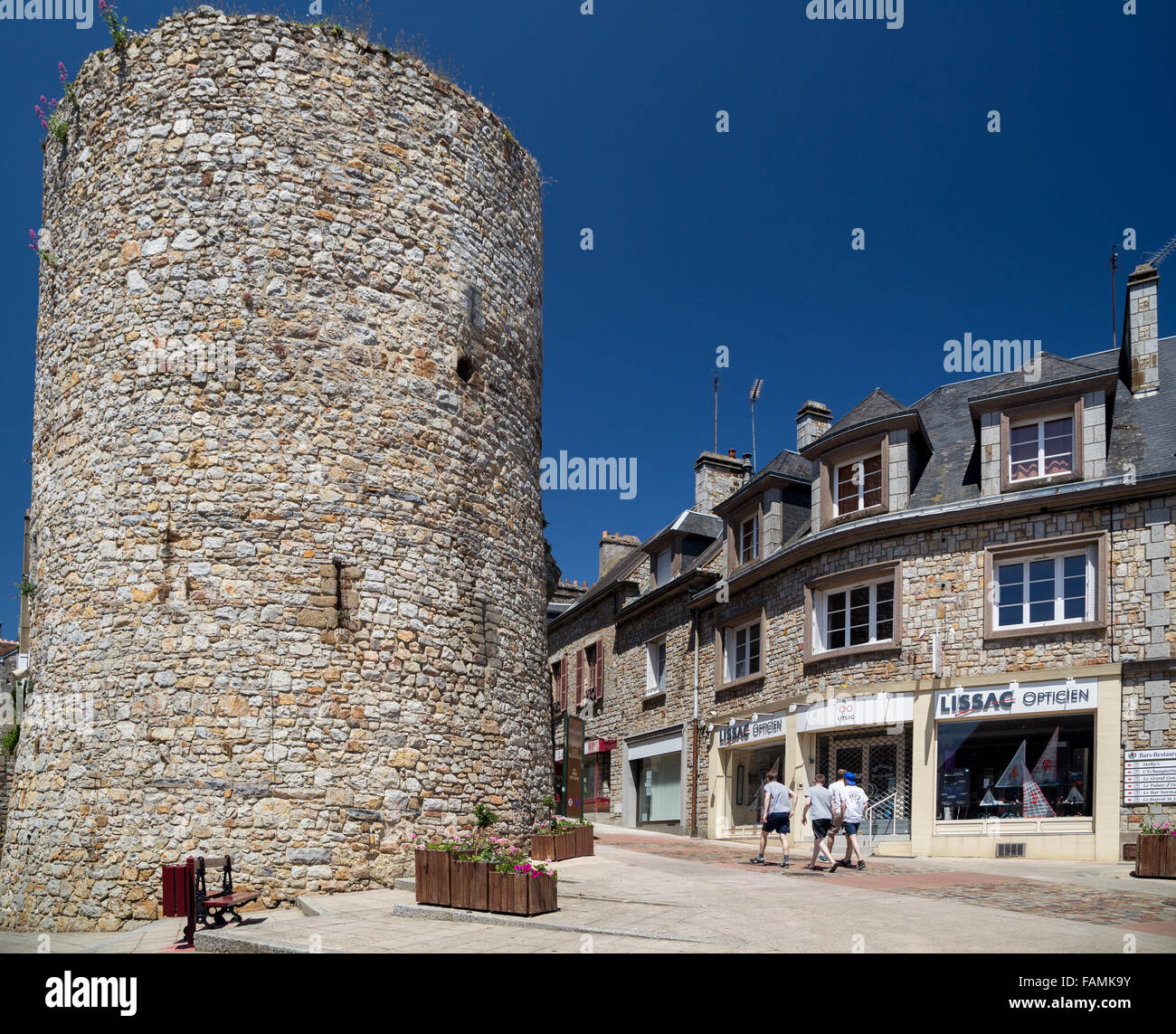 The historic medieval gate tower entrance to Domfront Castle and shops ...