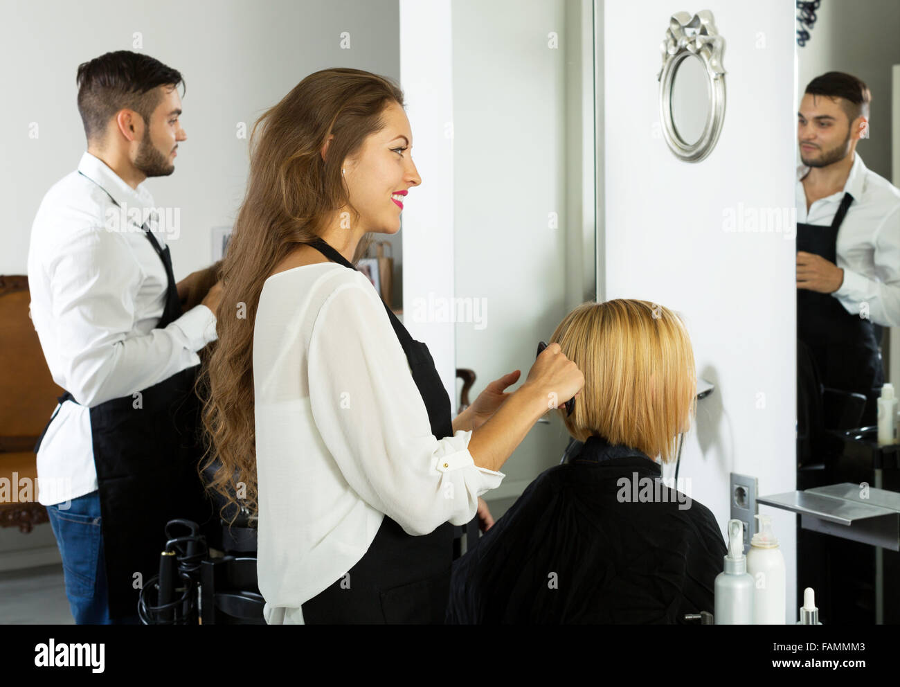 Hair stylist working on haircut for female client Stock Photo - Alamy
