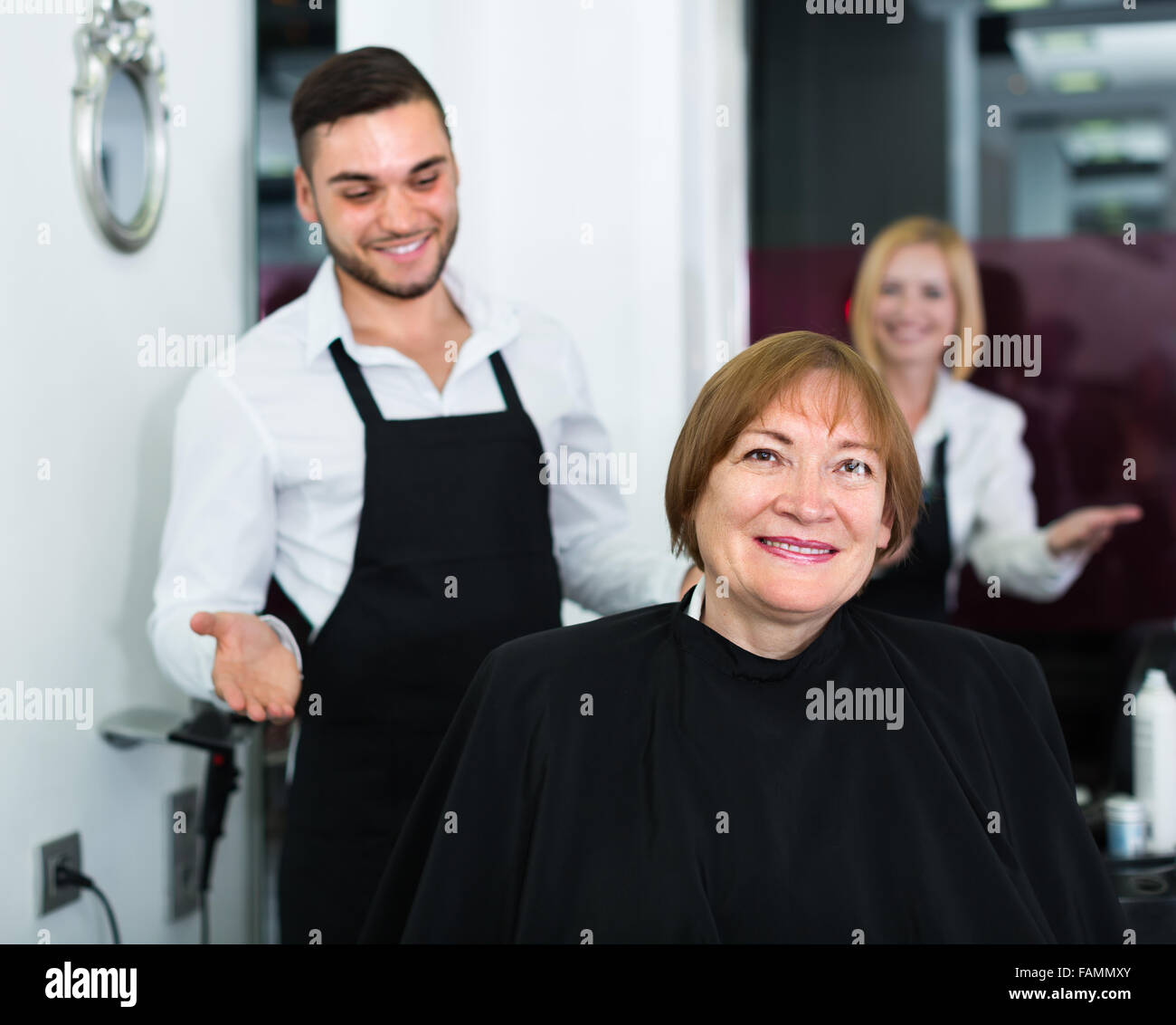 Portrait of smiling elderly woman cutting hair in the barbershop Stock ...