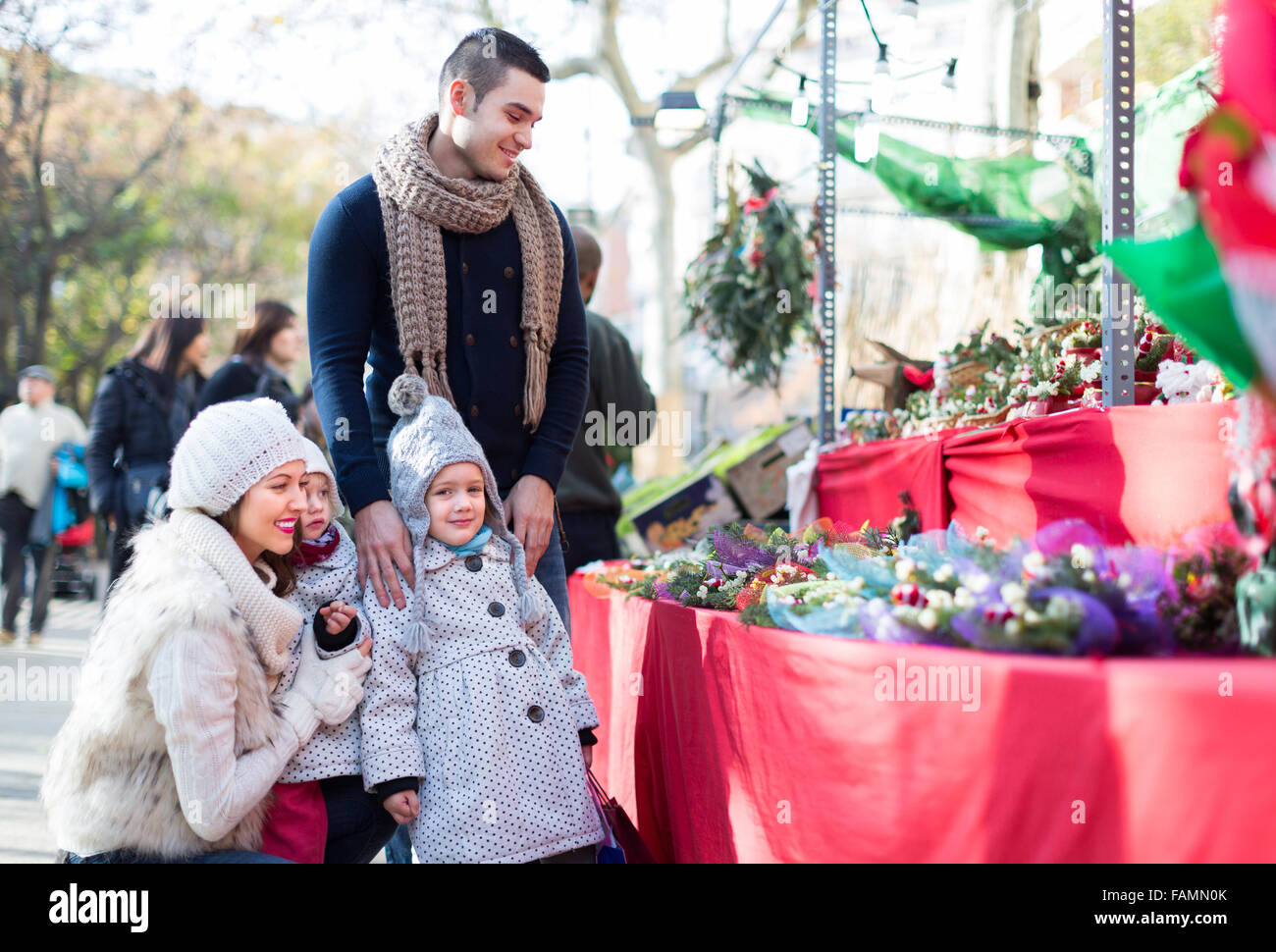 Young smiling parents with little girls at counter with Poinsettia ...