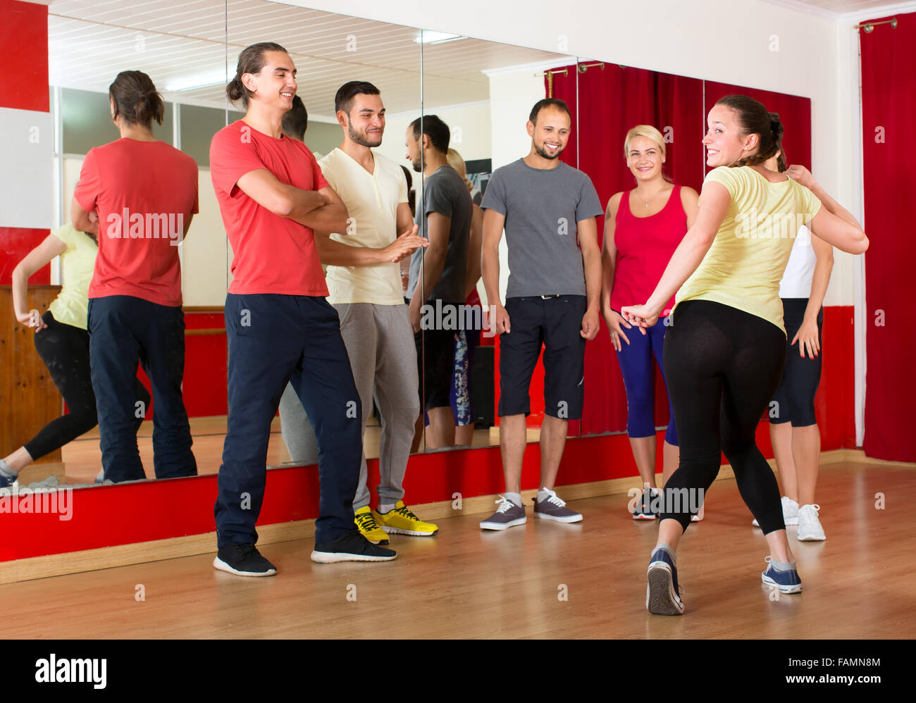 Dancing teacher showing new moves to group of students at a dancing ...