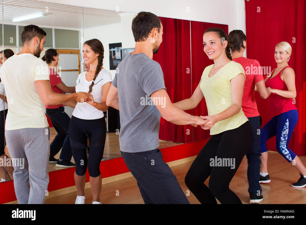 Happy men and women enjoying active dance at a dance studio Stock Photo ...