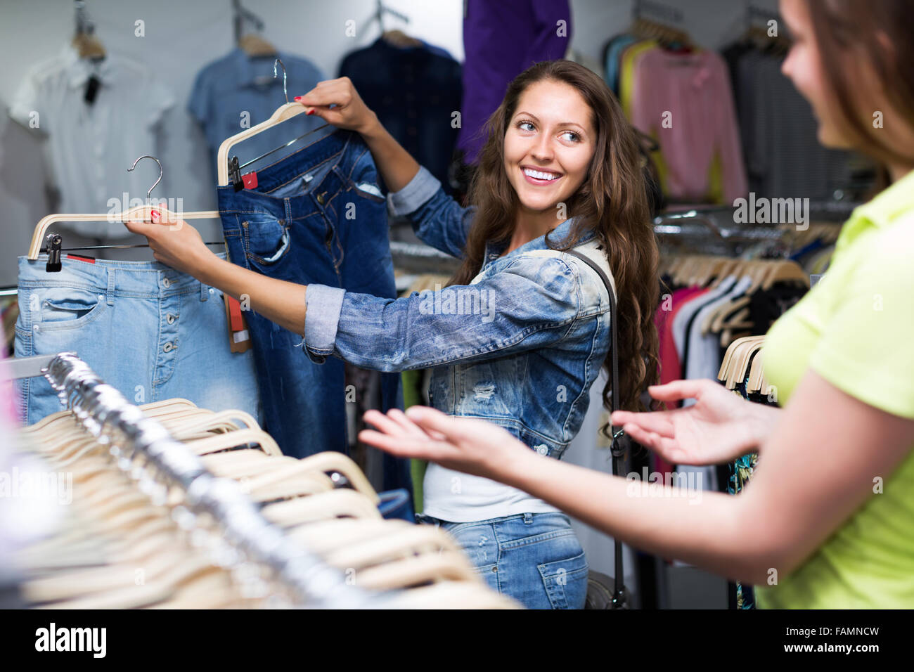 Happy young girl buying pants in clothing store Stock Photo - Alamy