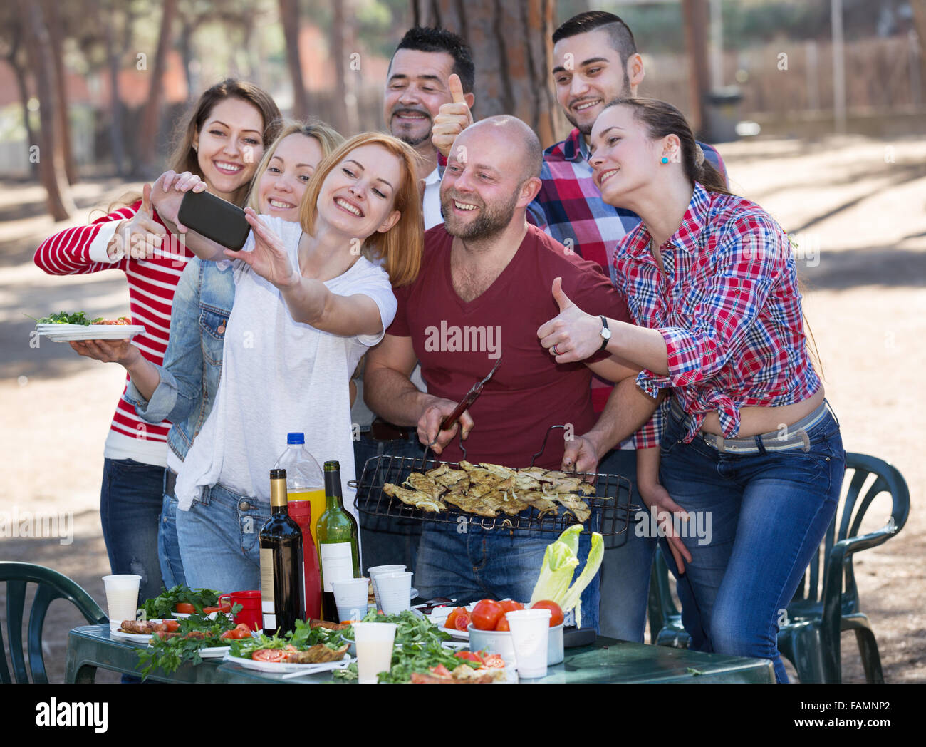 Happy cheerful adults relaxing at picnic and doing selfie Stock Photo ...
