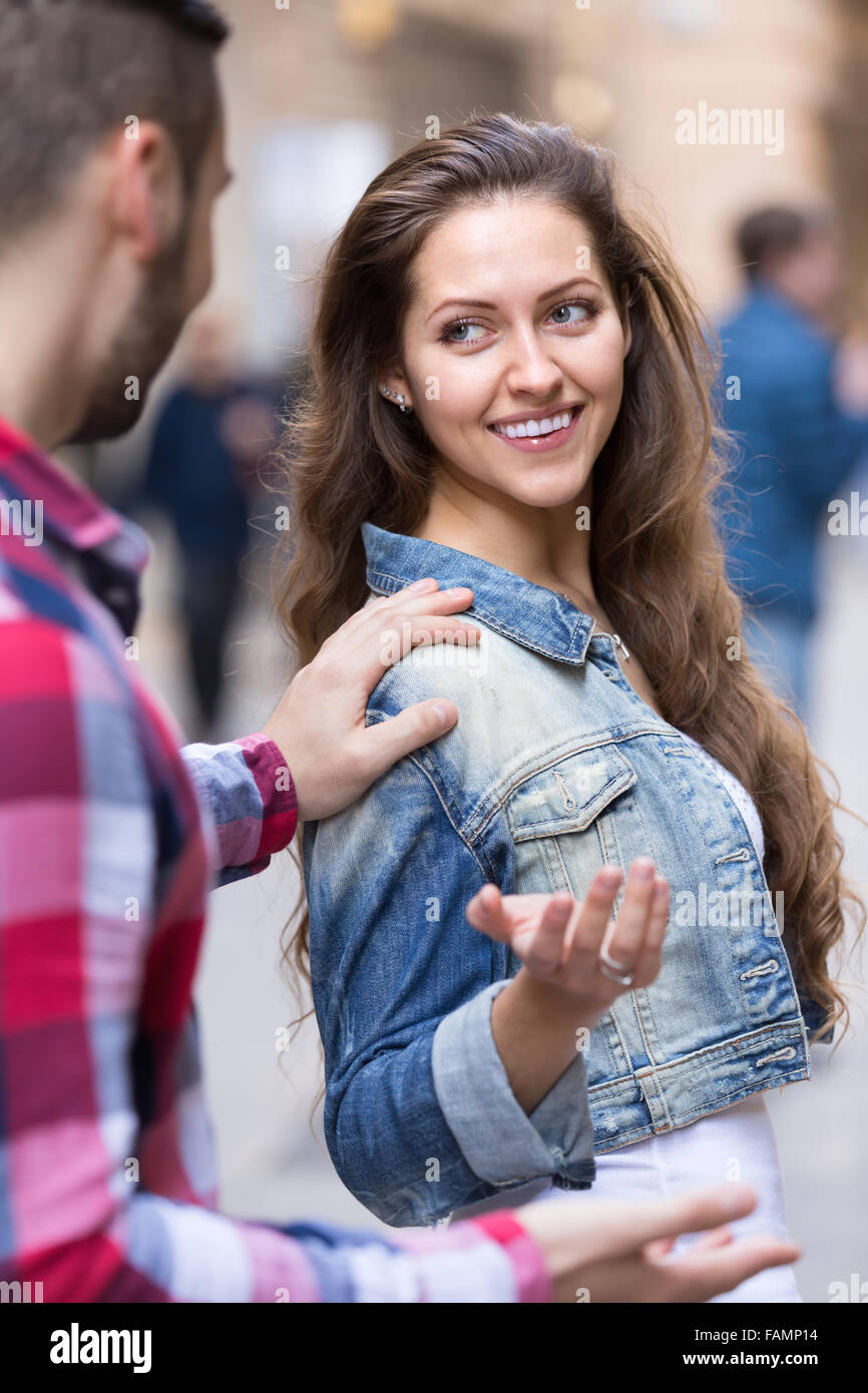 Attractive long-haired girl smiling back at nice-looking male stranger ...