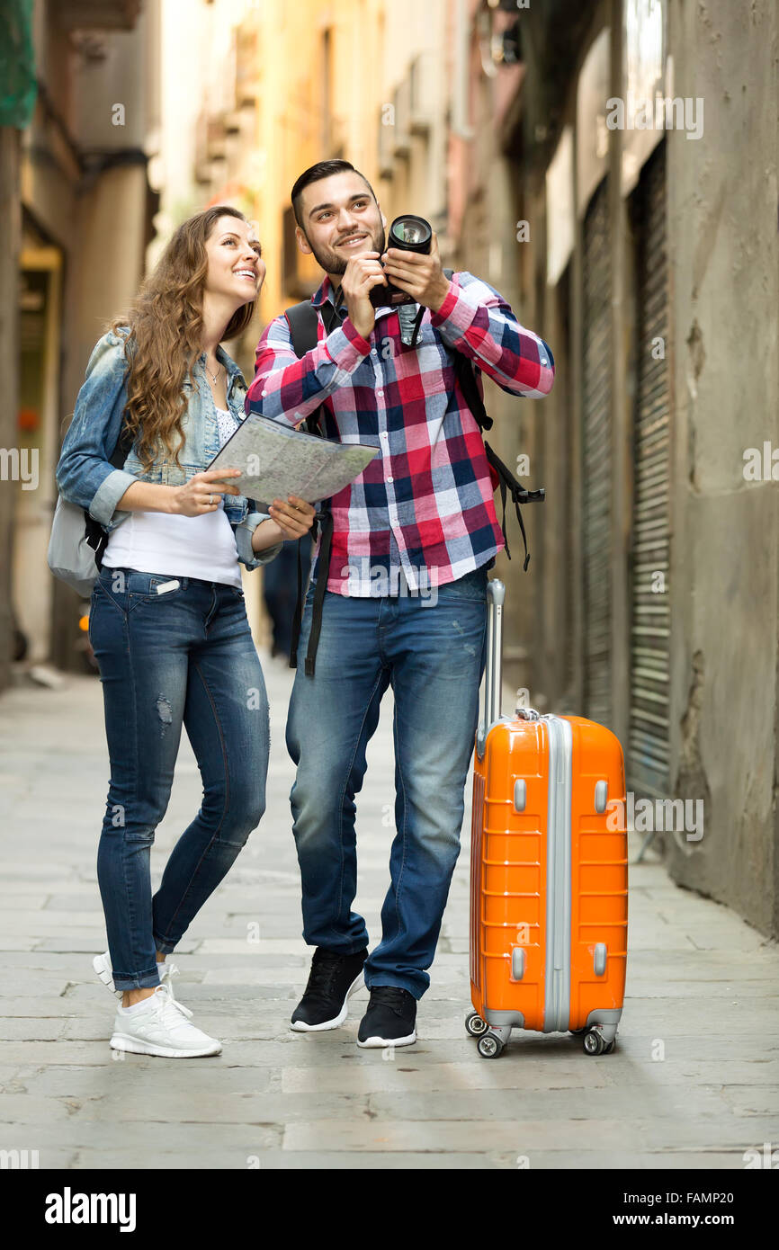 Man and woman travellers visiting old town and taking photographs of ...