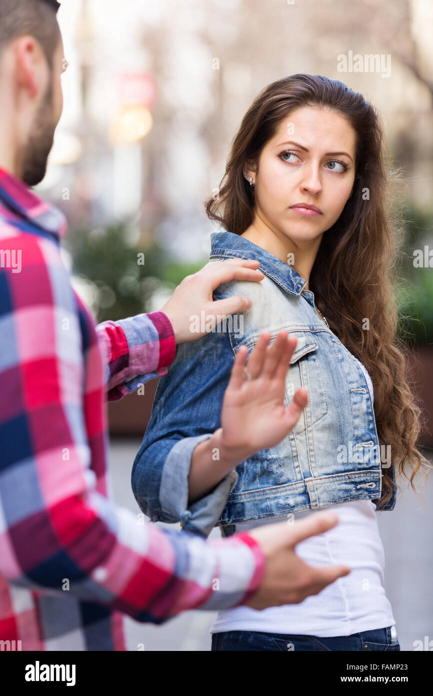 Male person accosting to young girl at crowded street Stock Photo - Alamy