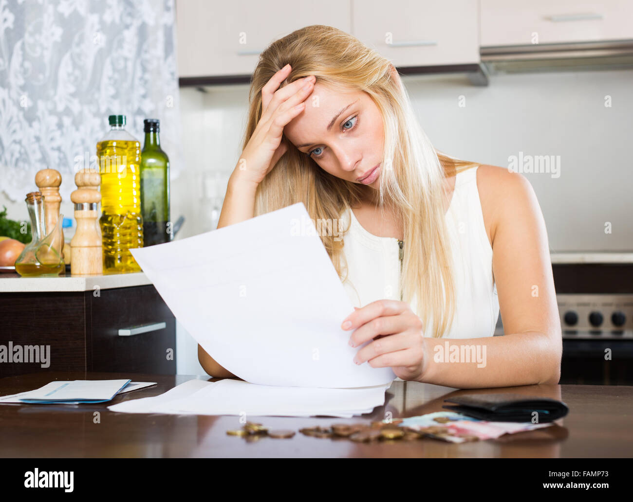 Sad blonde woman calculating the family budget at home Stock Photo - Alamy