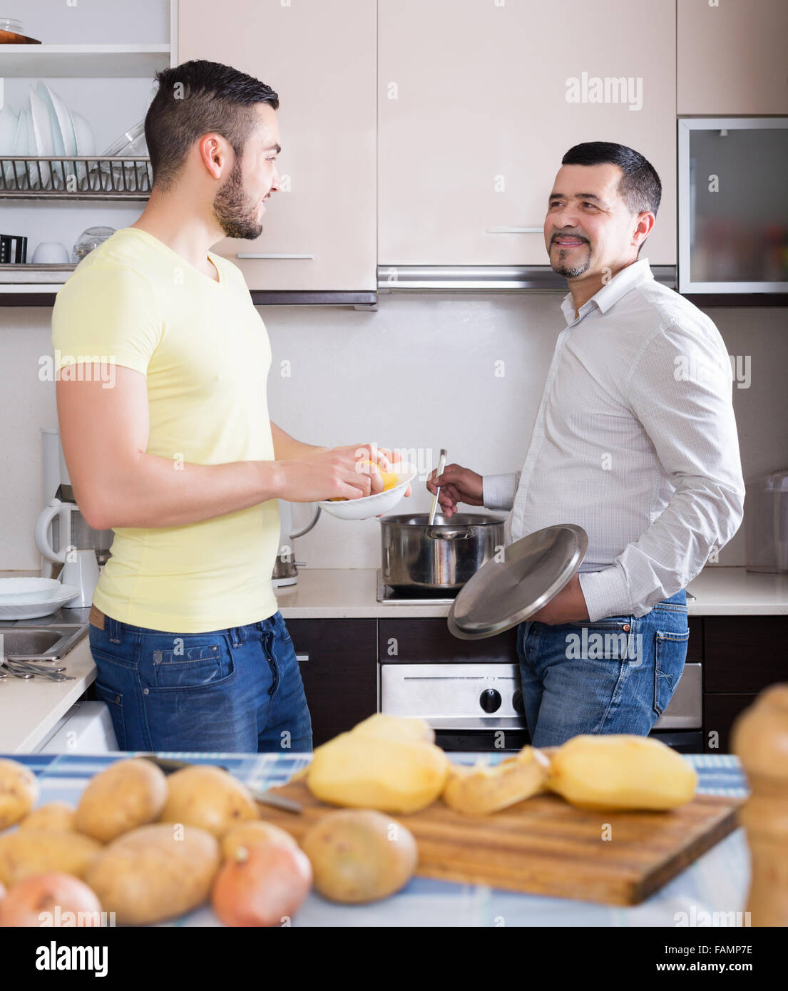 Son helping father to prepare vegetable stew at kitchen Stock Photo - Alamy