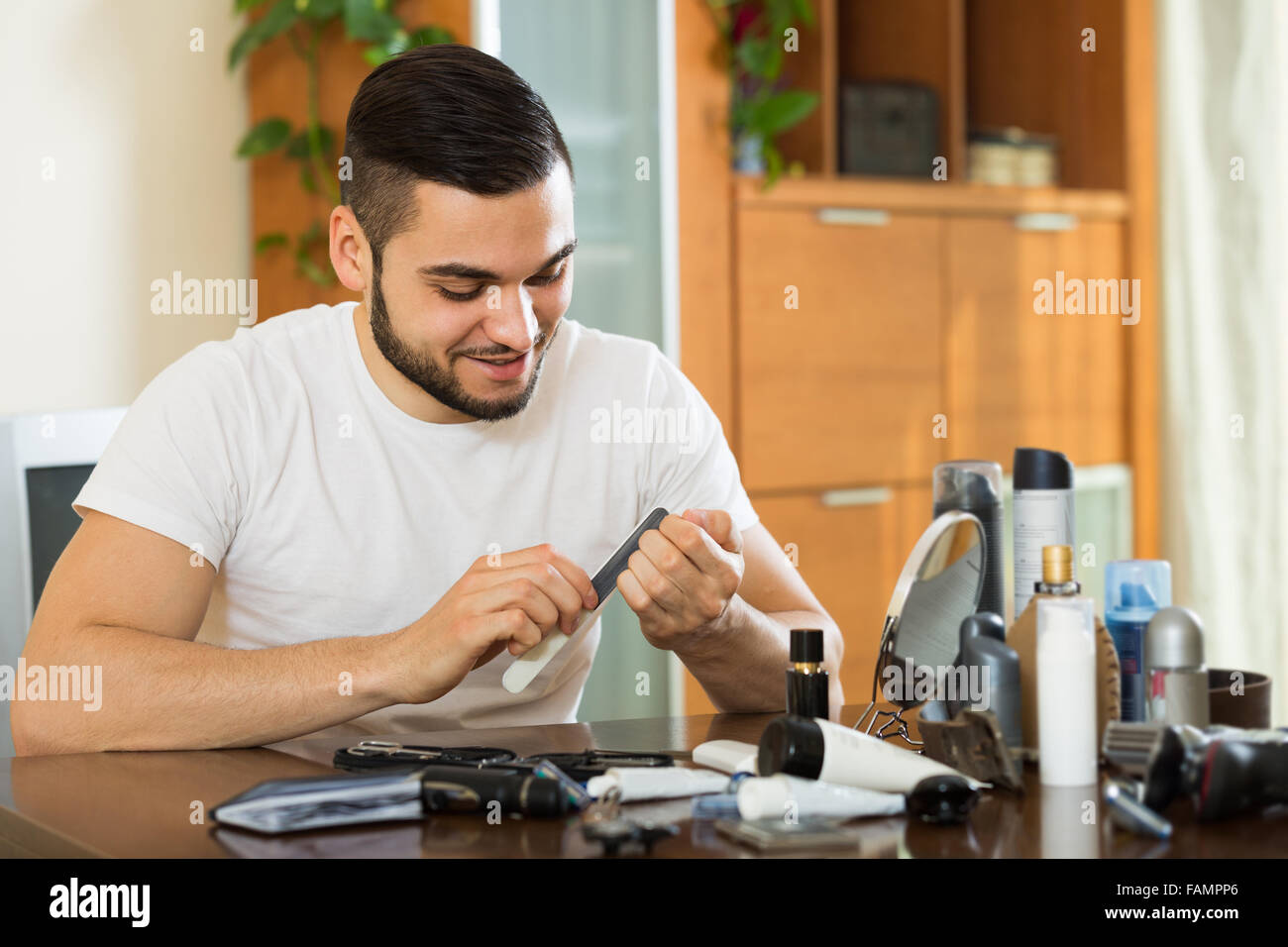 Handsome american man using nail file Stock Photo - Alamy