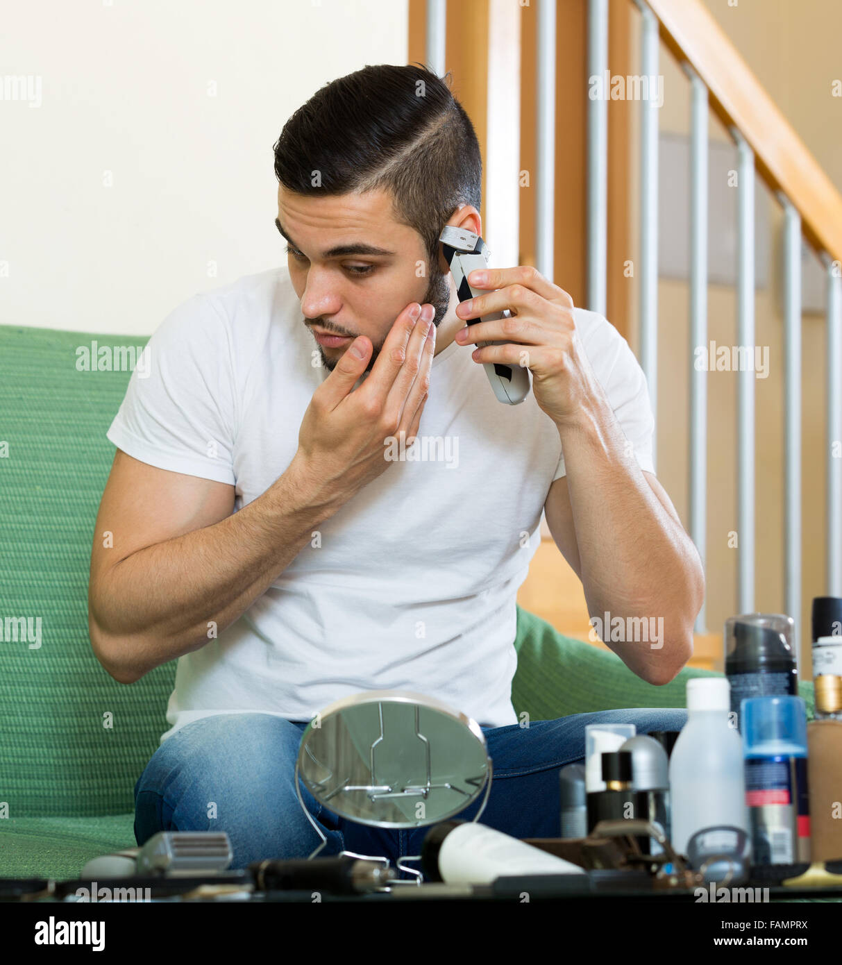 Handsome man shaving his face with an electric razor Stock Photo - Alamy