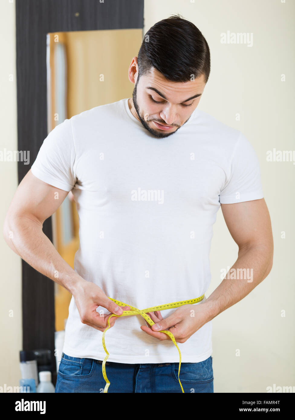 Handsome american man measuring his bicep and body Stock Photo - Alamy