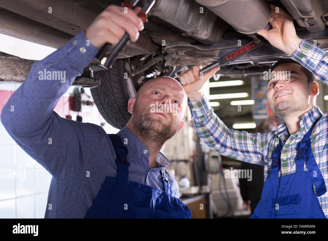 Professional mechanics repairing car of client Stock Photo - Alamy