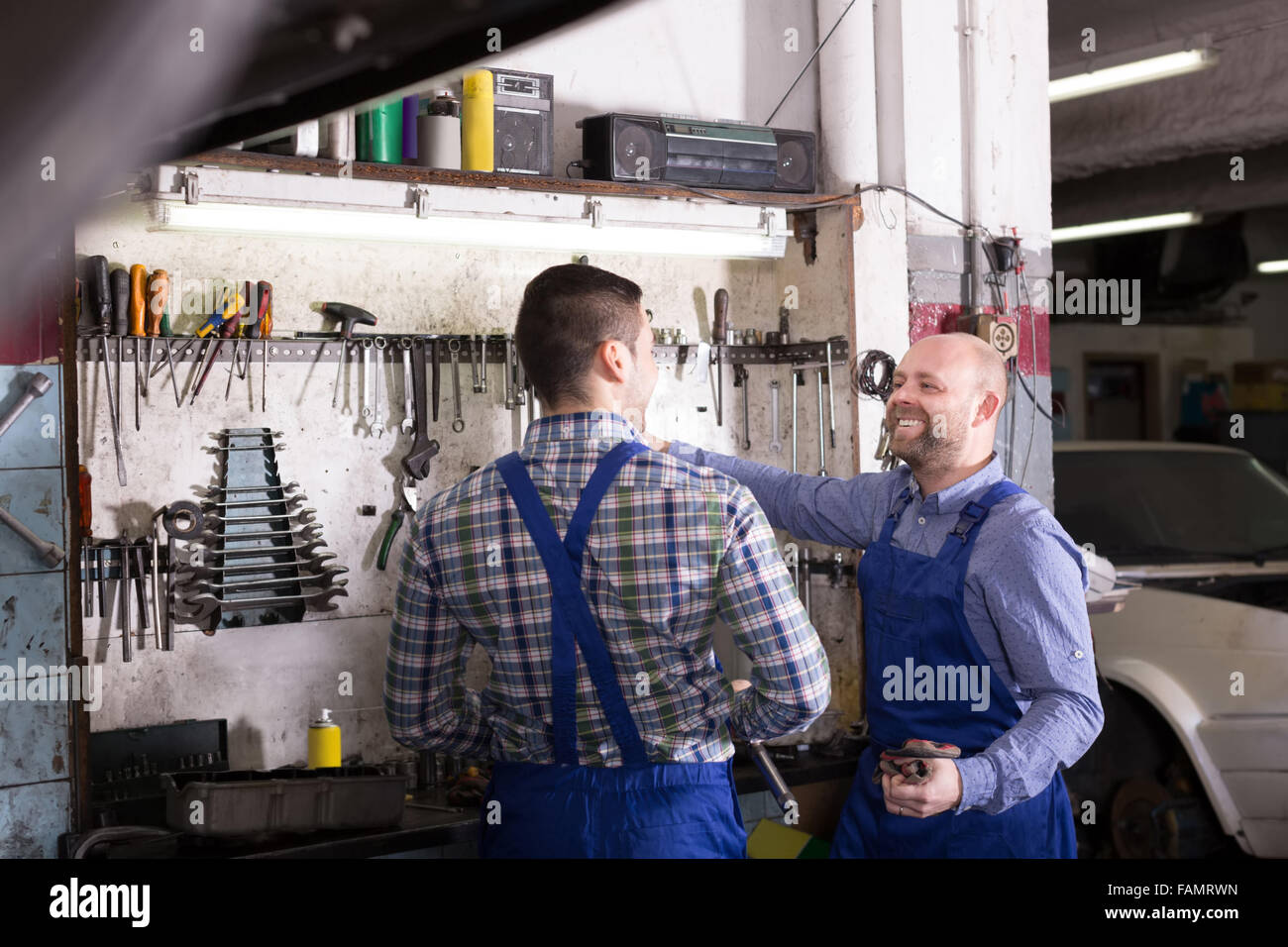 happy european men in coveralls working at carshop Stock Photo - Alamy