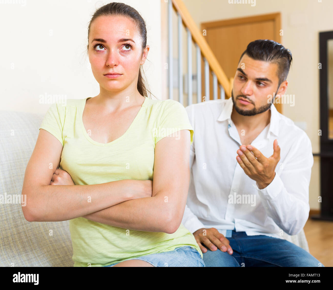 Sad Young Couple Sitting At The Sofa And Having Quarrel Focus On Girl