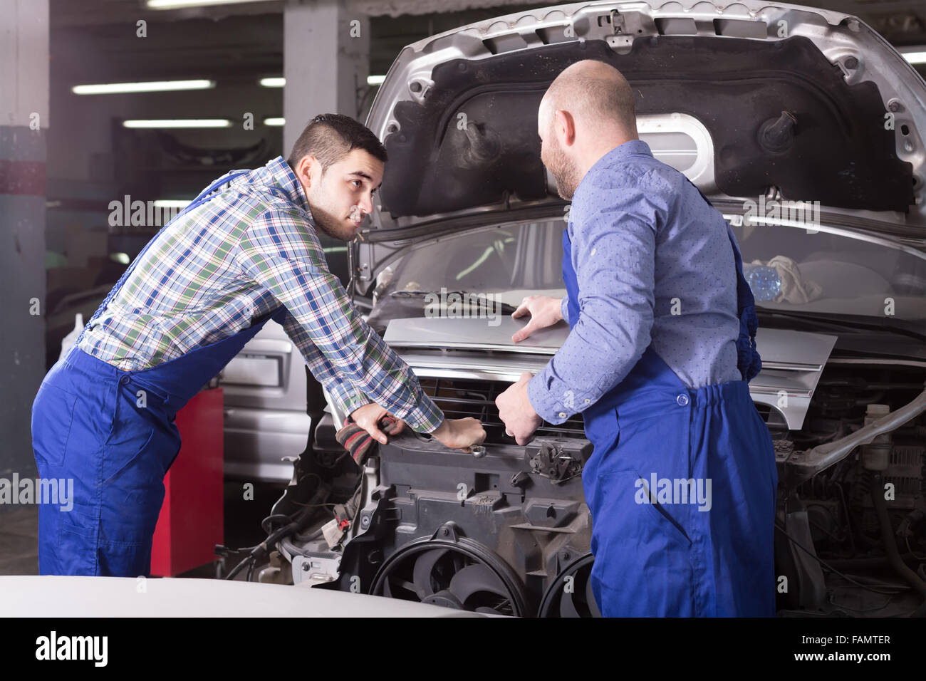 Two serious car mechanics working together at workshop Stock Photo - Alamy