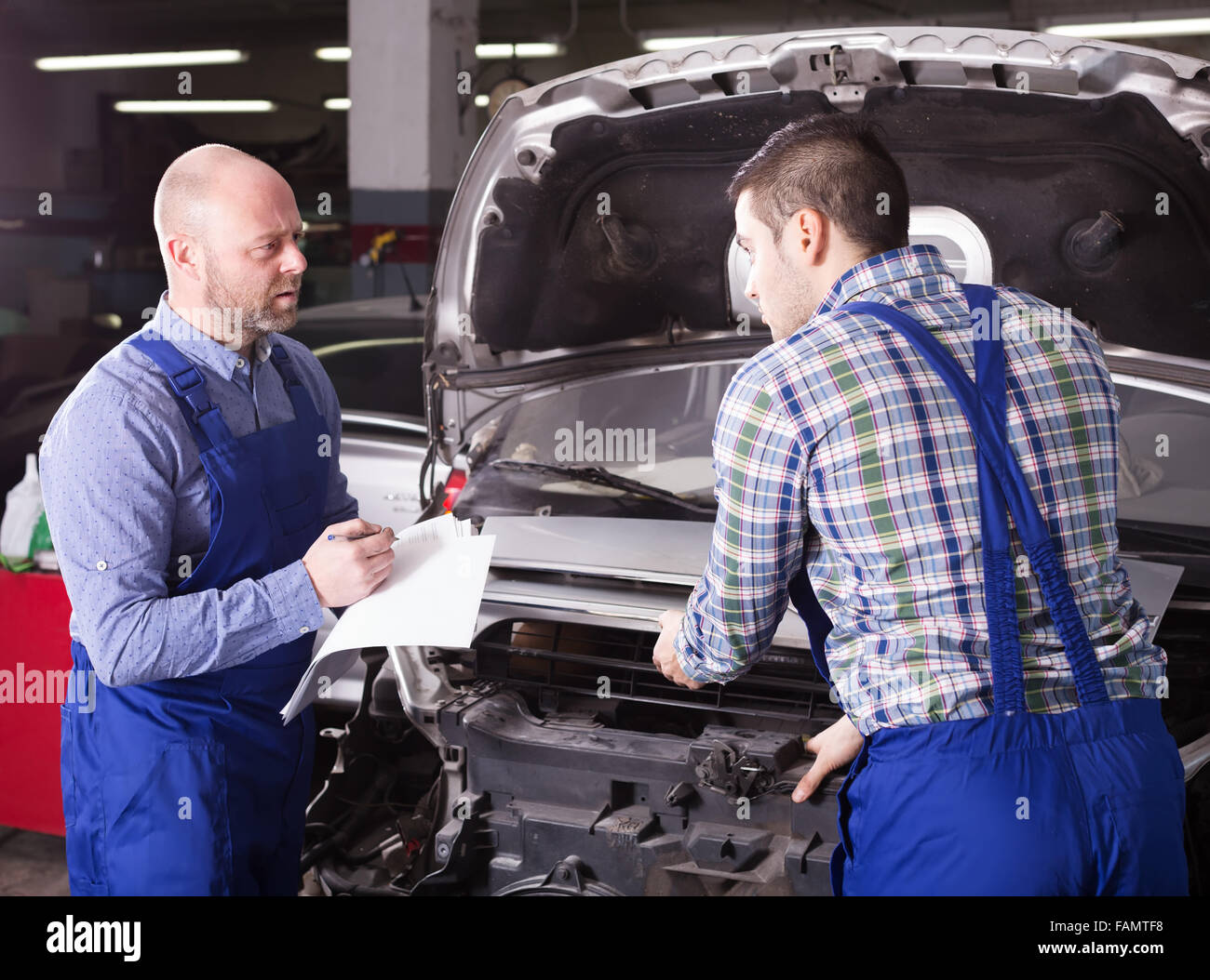 Workman calculating the price of work at auto repair workshop Stock ...