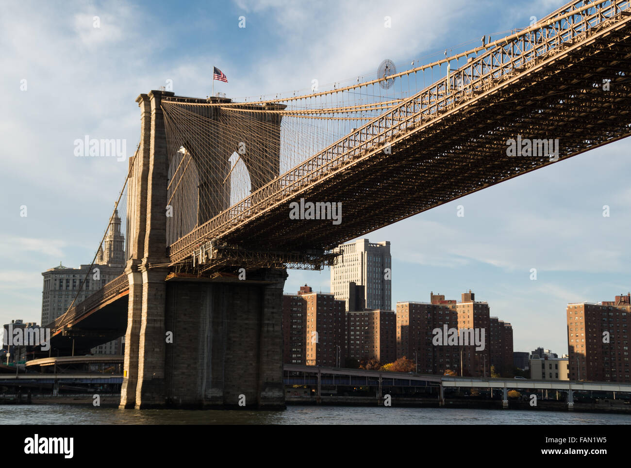 Brooklyn Bridge entering Manhattan with an American flag flying Stock ...
