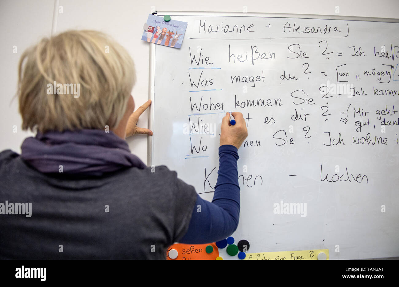 A volunteer helper writes on the board during a German lesson at the ...