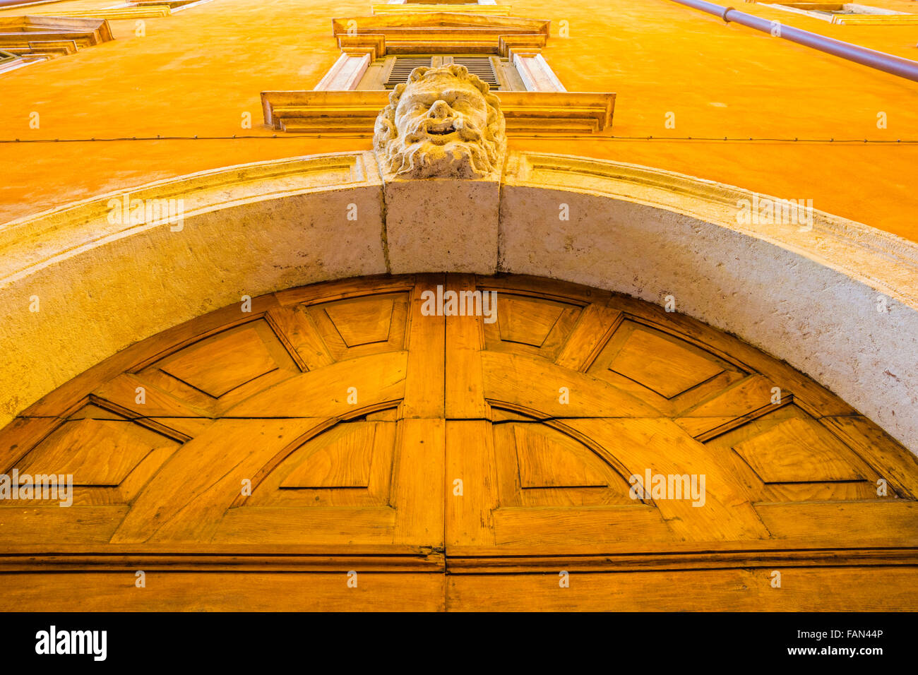 large wooden gate into courtyard of appartment block with figure head ...