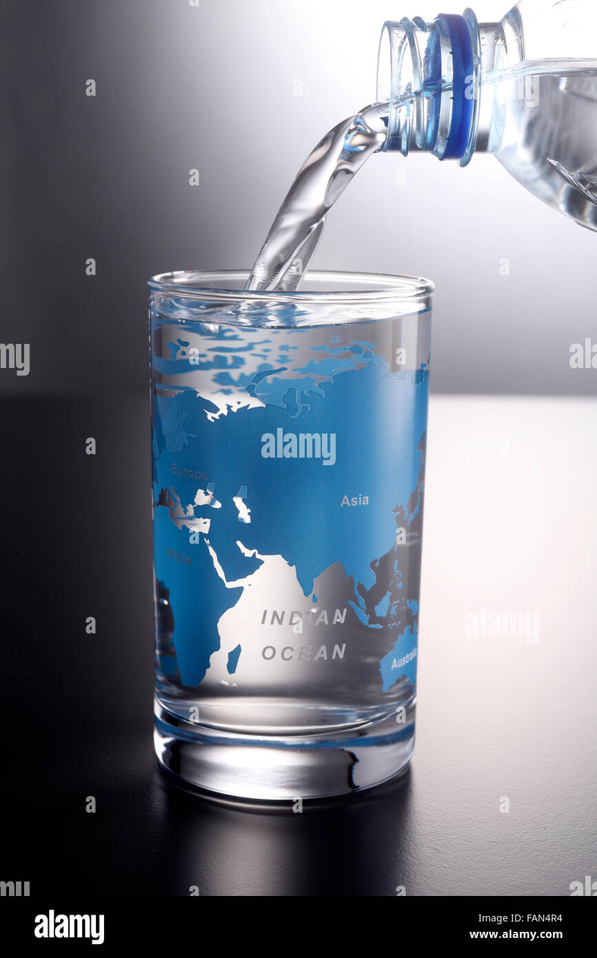 pouring water into a glass printed world map Stock Photo - Alamy