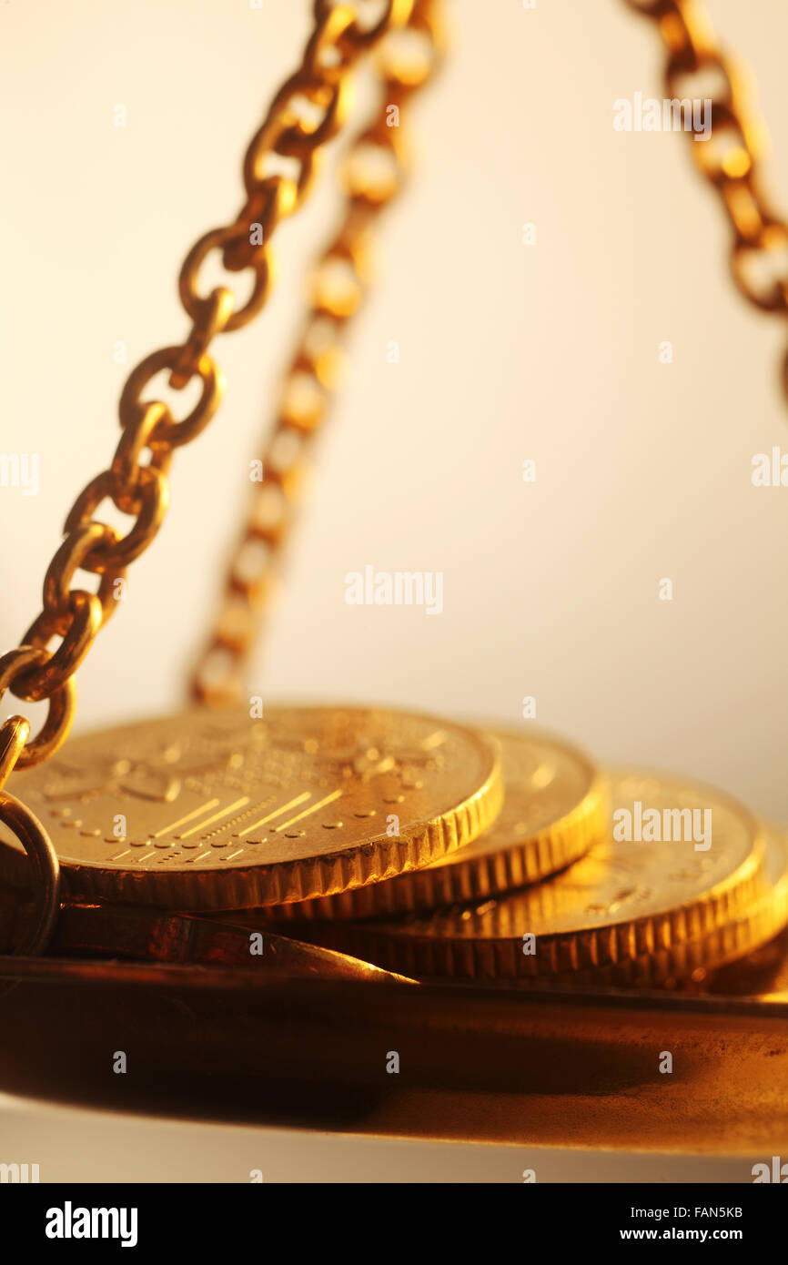 stacks of bright new shiny gold coins placed on weighing scales Stock ...