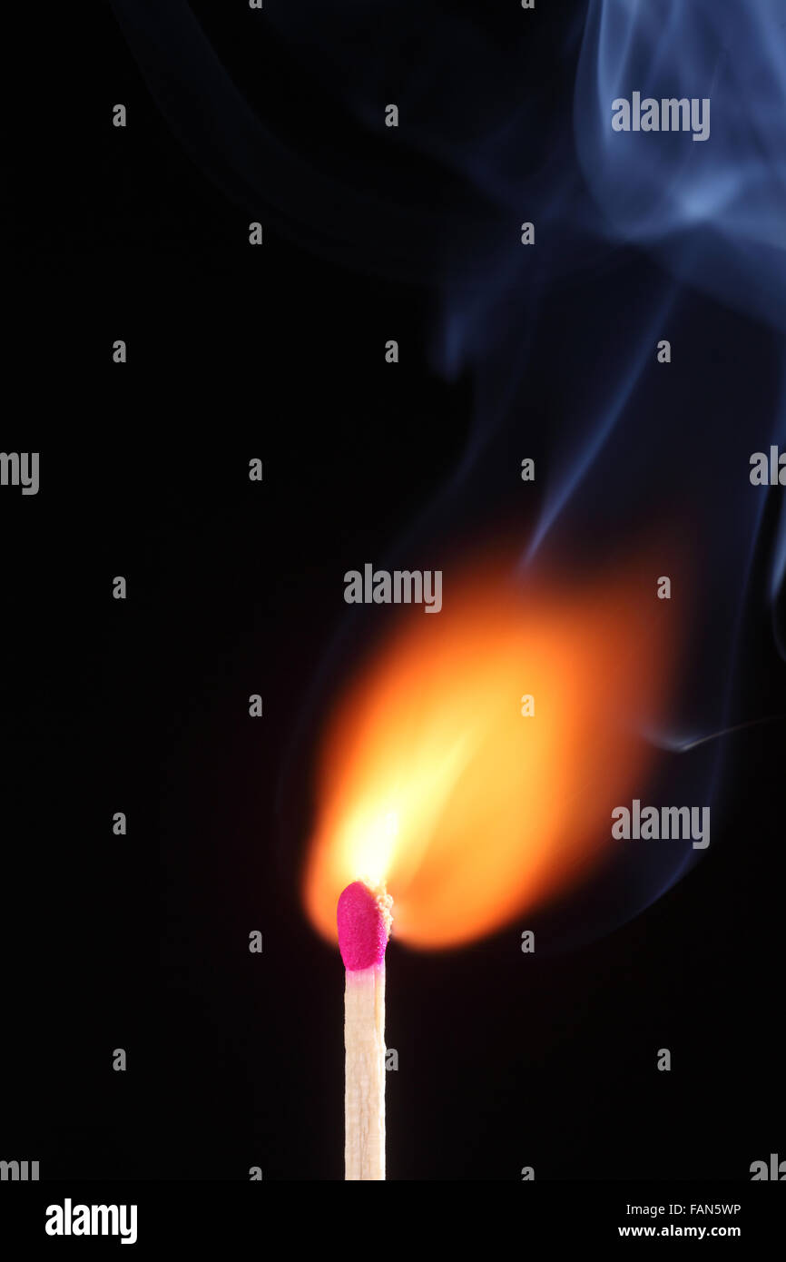 Match ignited on the black Stock Photo - Alamy