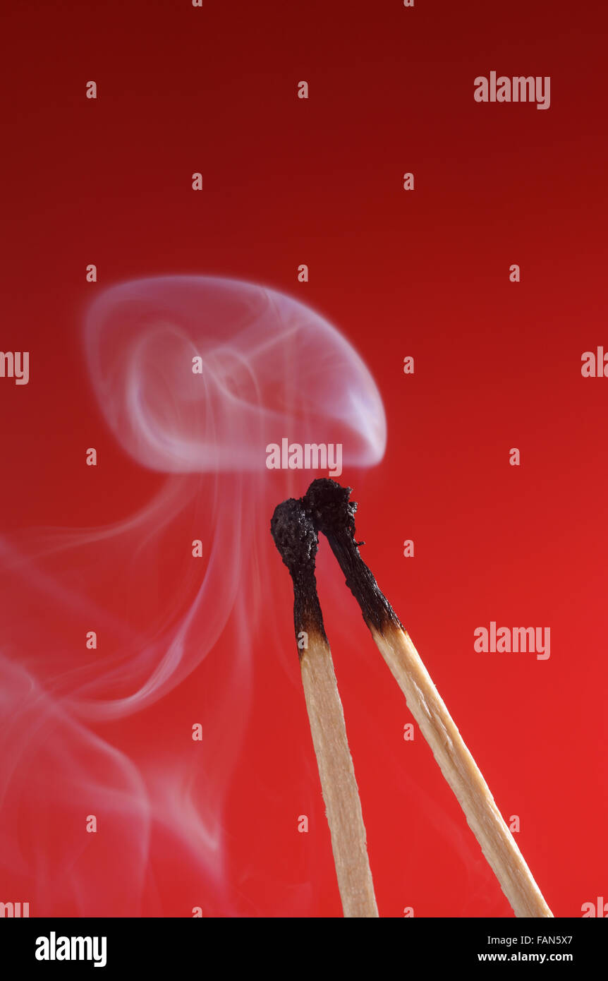 extinguished match smoking on the red Stock Photo - Alamy