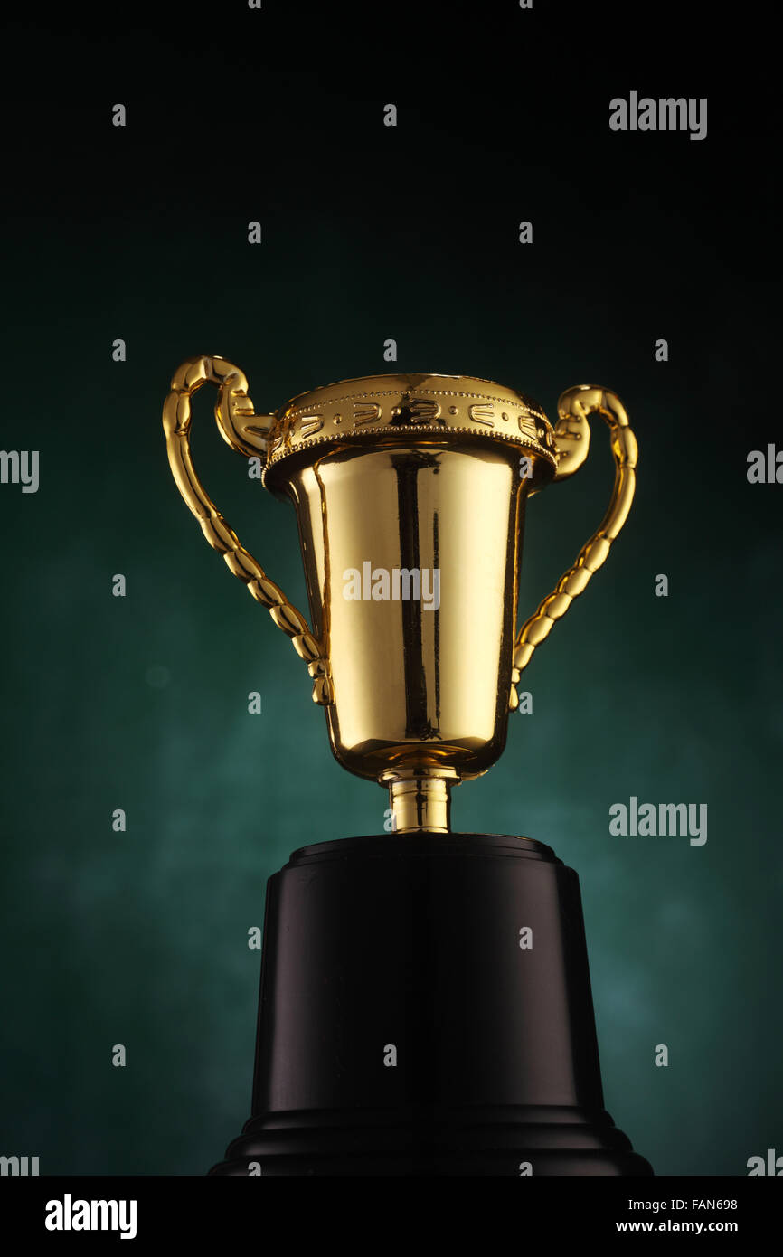 Golden trophy on green background Stock Photo - Alamy