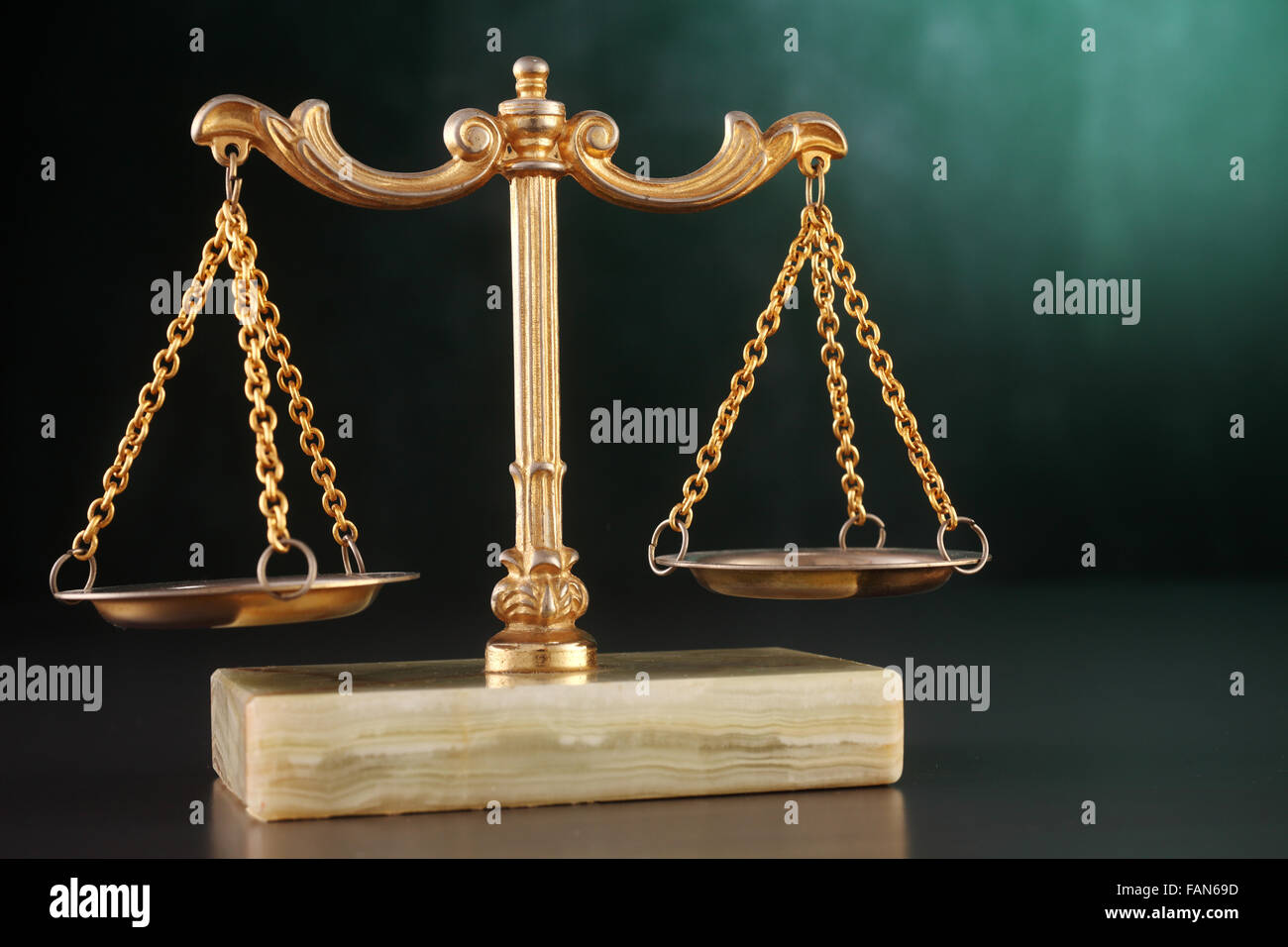 Balanced weight scale against green background Stock Photo - Alamy