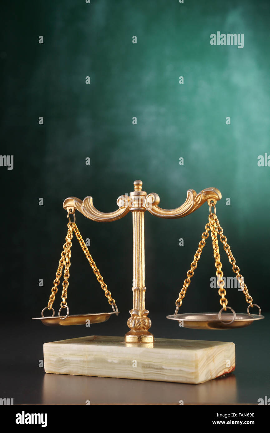 Balanced weight scale against green background Stock Photo - Alamy