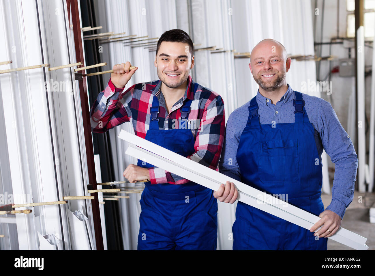 Two positive adult workers posing in PVC shop Stock Photo - Alamy