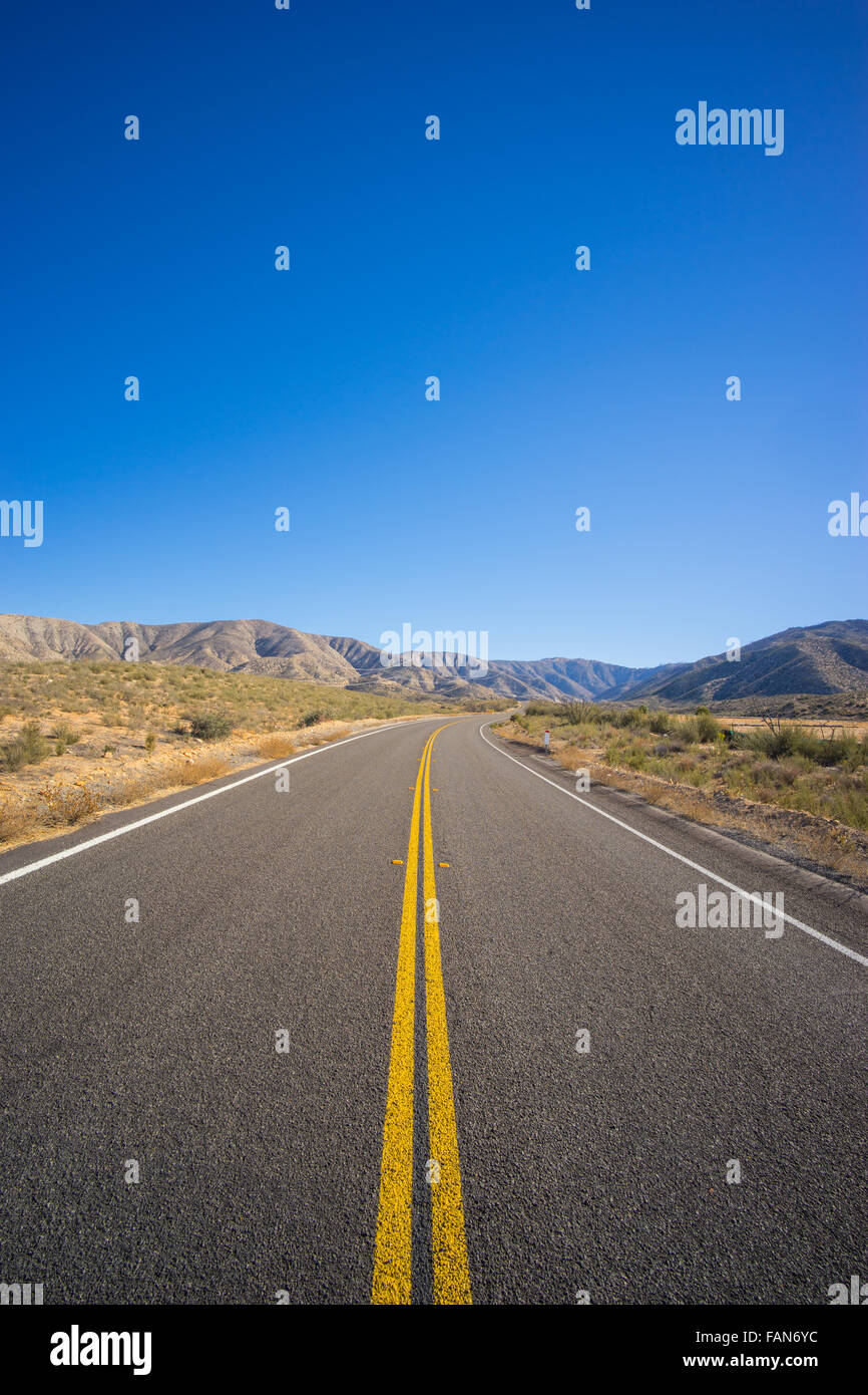 Long view of desert road leading into wilderness nature area of Mojave ...