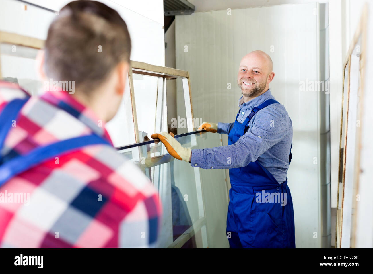 Adult workers working with glass for windows at workshop Stock Photo ...