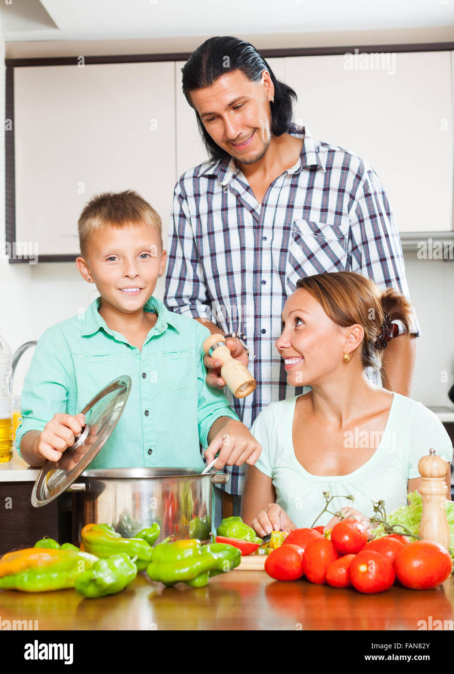 Happy man and woman with boy adding spices or salt to the pot Stock ...