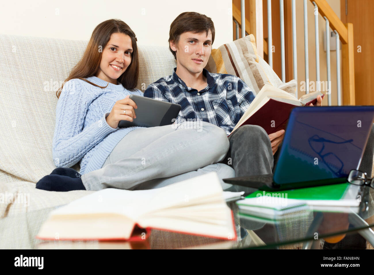 Student couple reading a book and educational materials before the exam ...