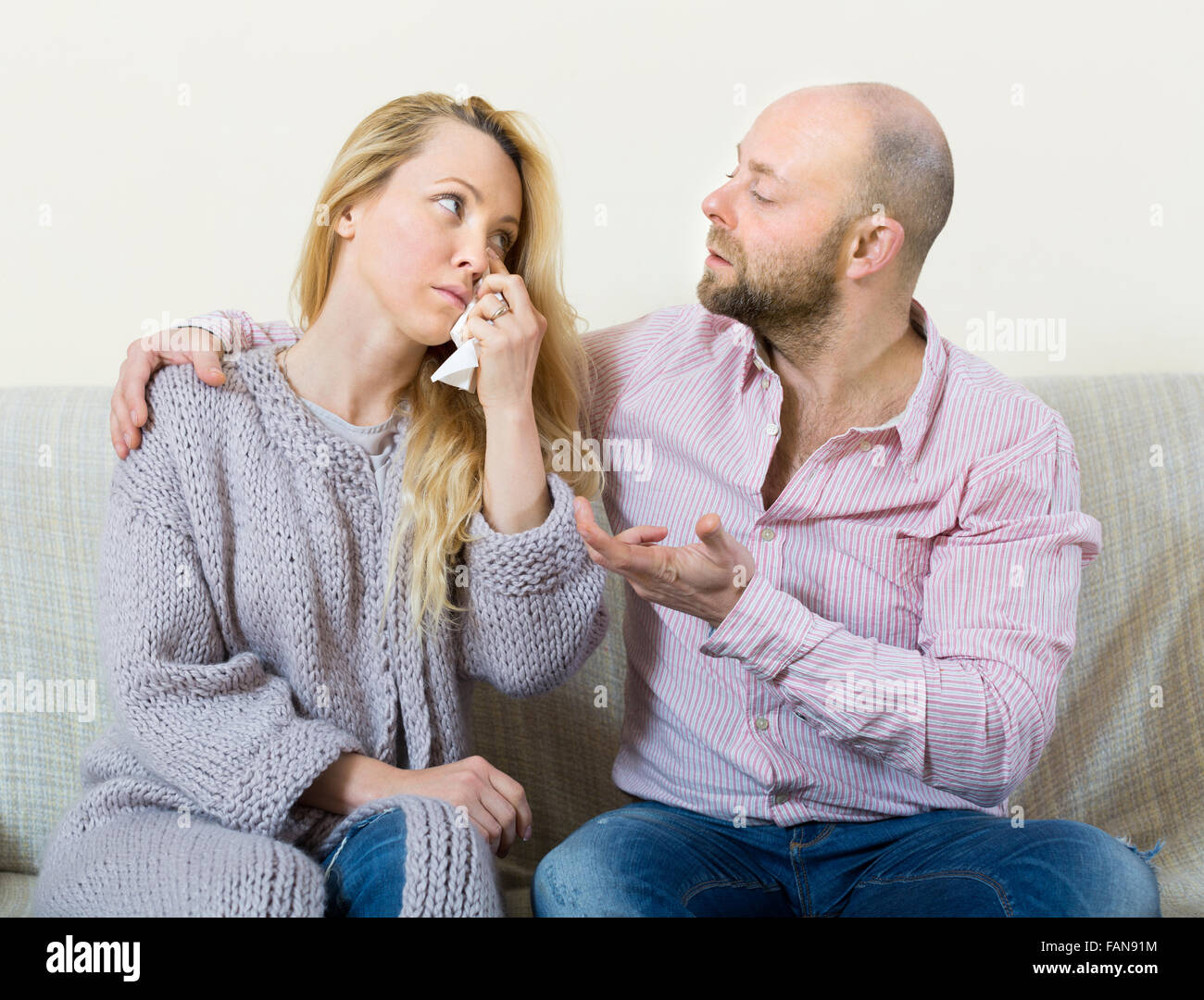 Man asking for forgiveness from crying woman after conflict at home ...