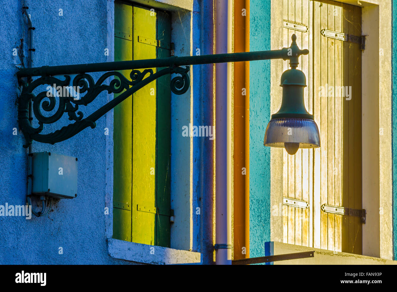 sunset light on rustic window shutters and plaster walls of building ...