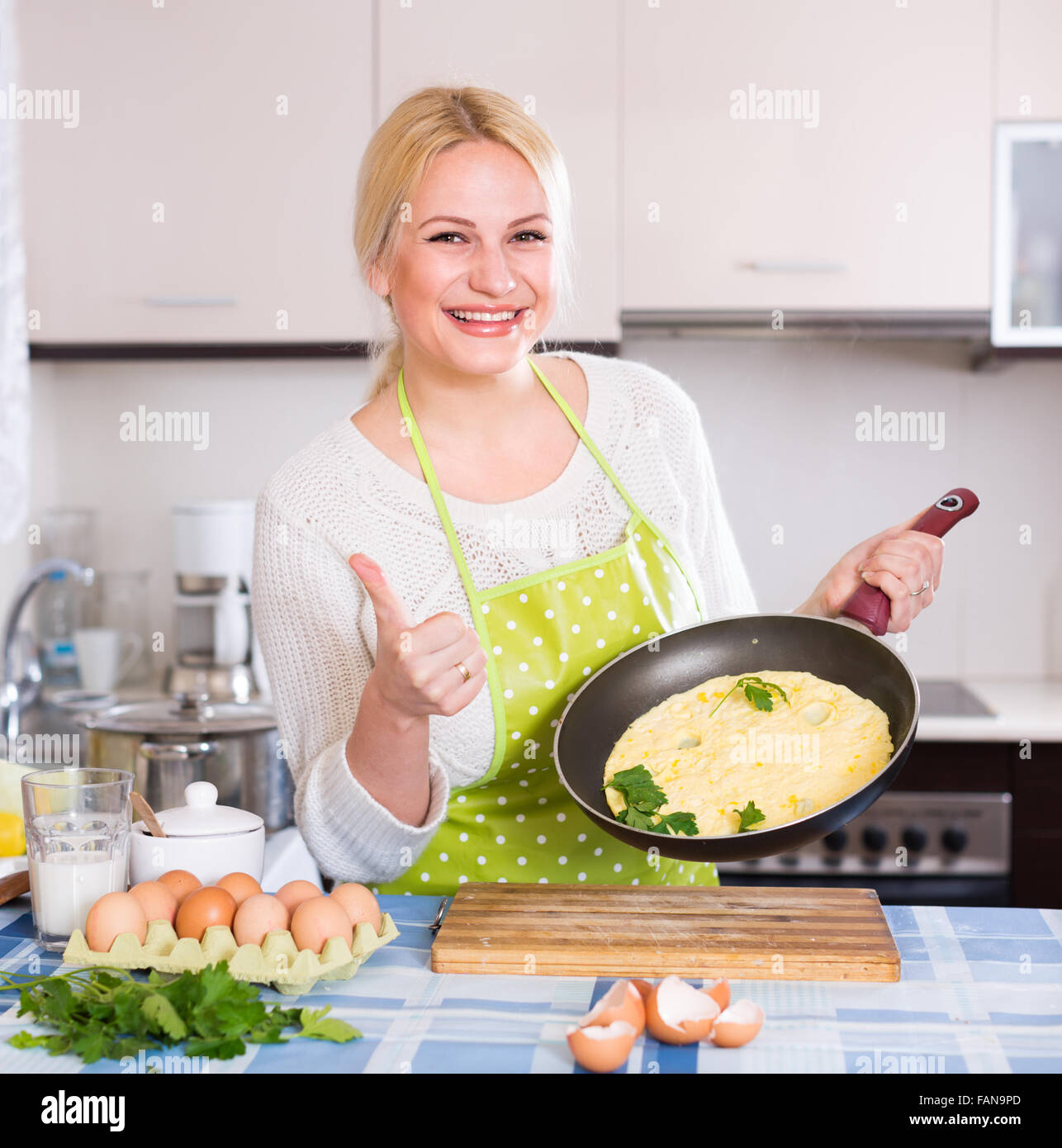 Smiling woman making omlet in kitchen Stock Photo - Alamy
