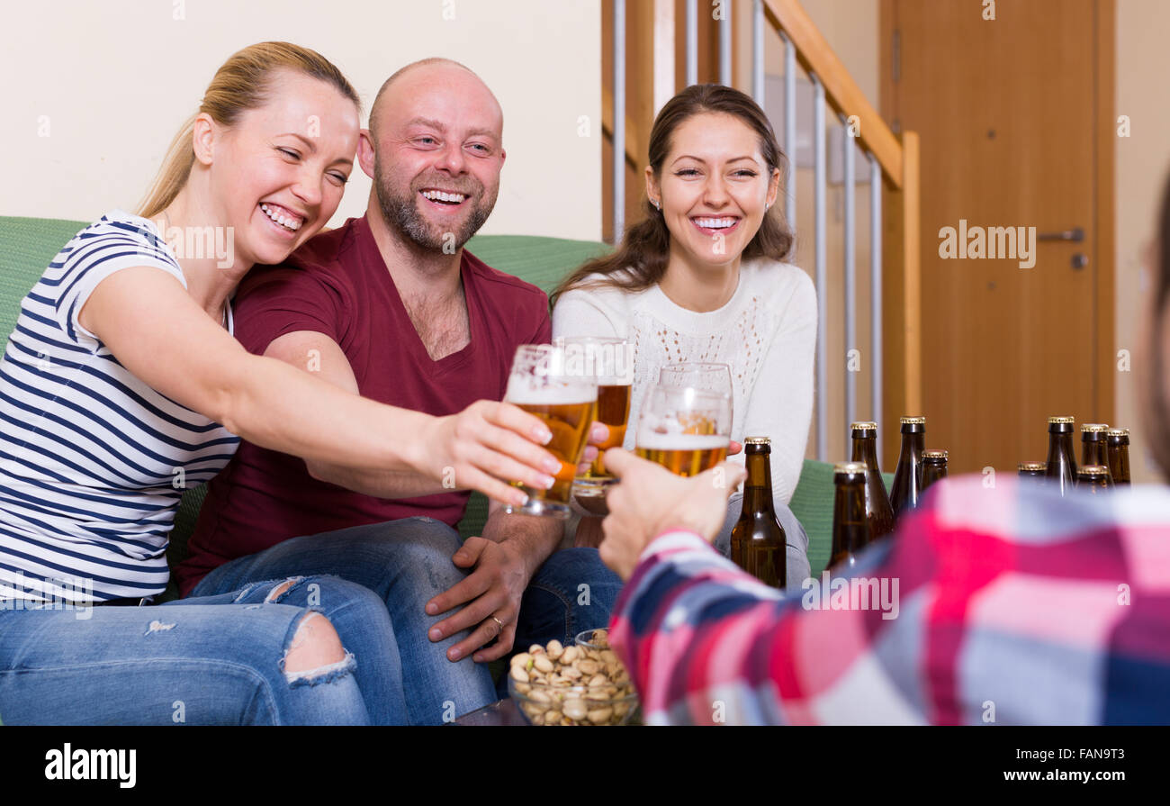Happy people drinking beer and laughing at home Stock Photo - Alamy