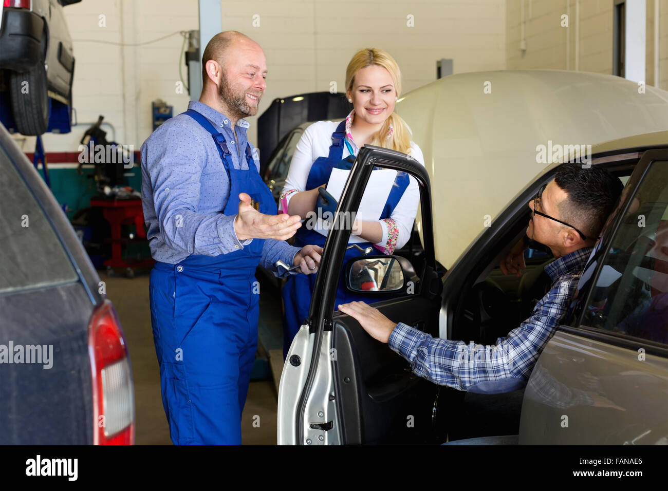 Service crew and happy driver standing near car Stock Photo - Alamy