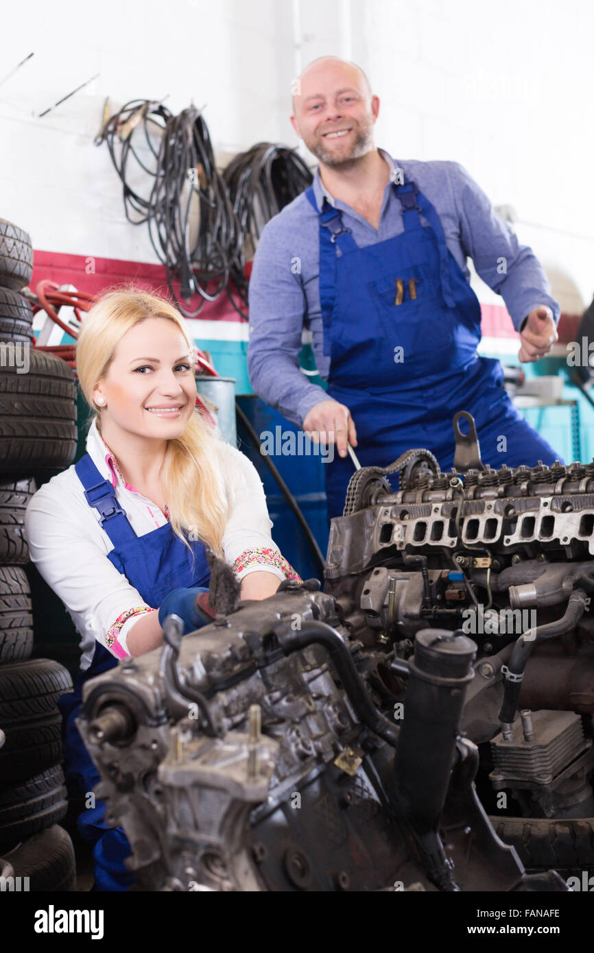 Handsome mechanic and female happy russian assistant working at auto ...