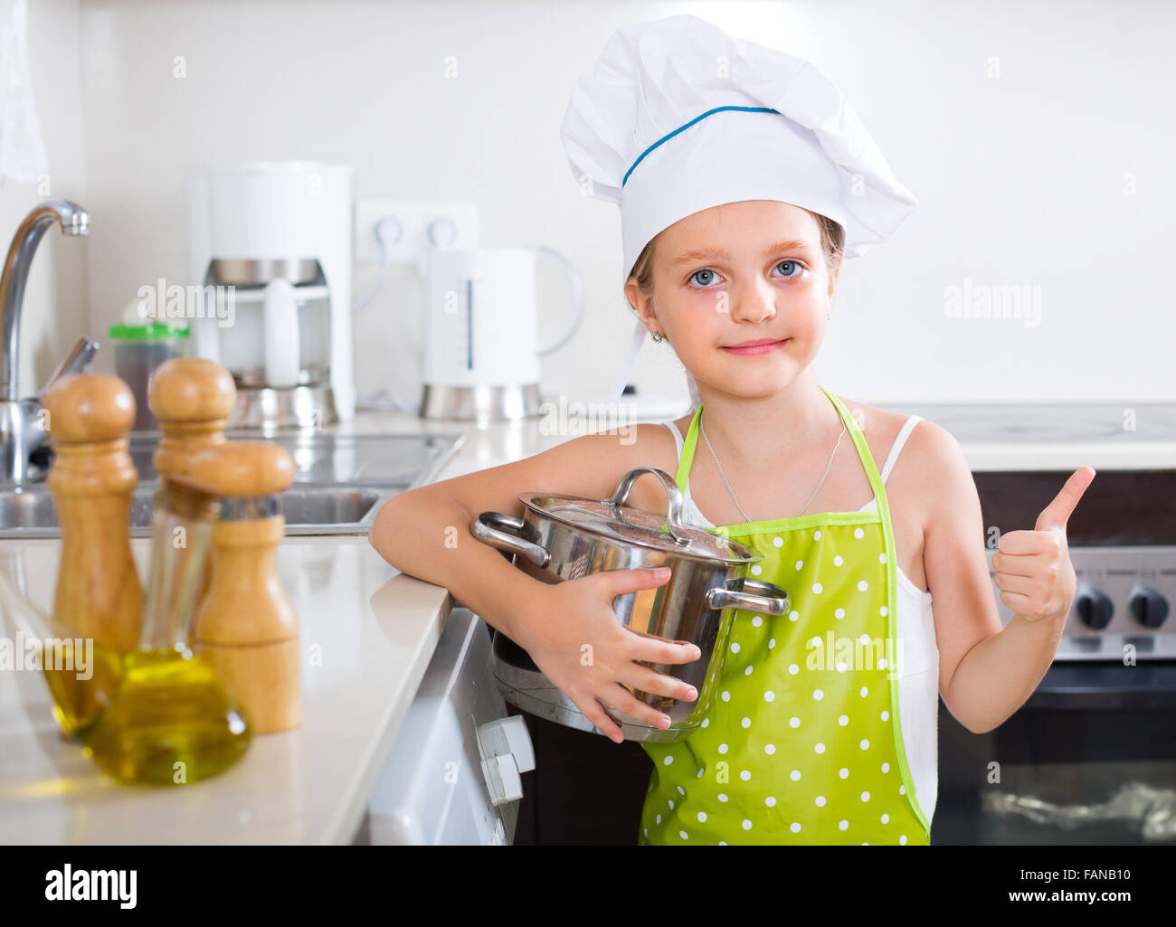 Smiling cute little girl cooking alone at kitchen Stock Photo - Alamy