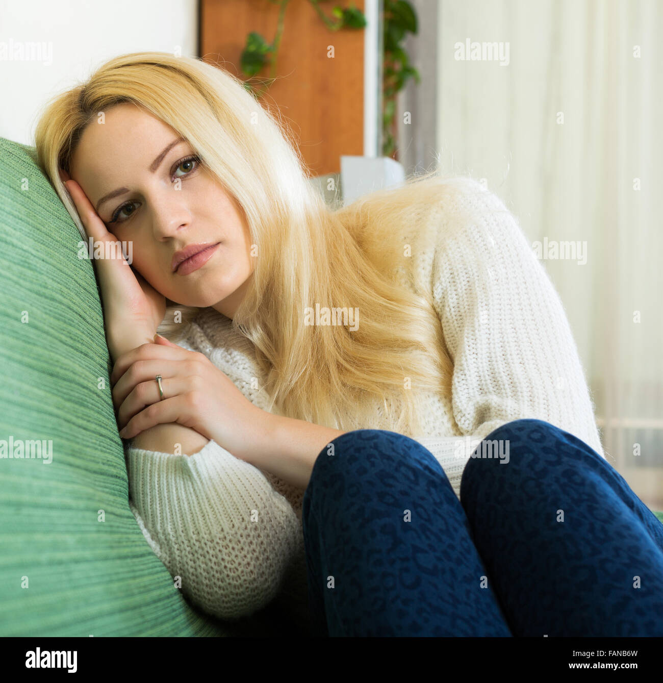 Depressed young woman sitting in silence and thinking about her ...