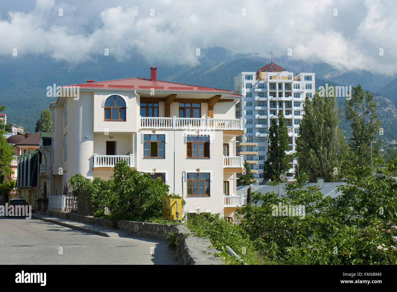 Modern buildings of different types and hills behind in town Yalta ...