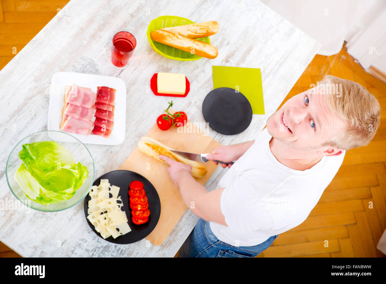 A young man preparing a sandwich in the kitchen Stock Photo - Alamy
