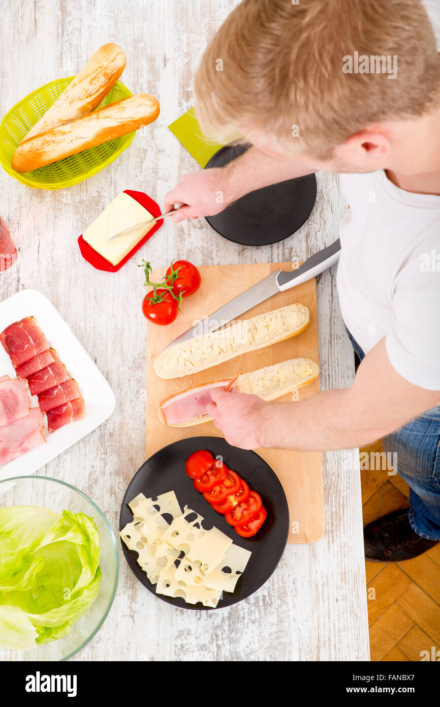 A young man preparing a sandwich in the kitchen Stock Photo - Alamy